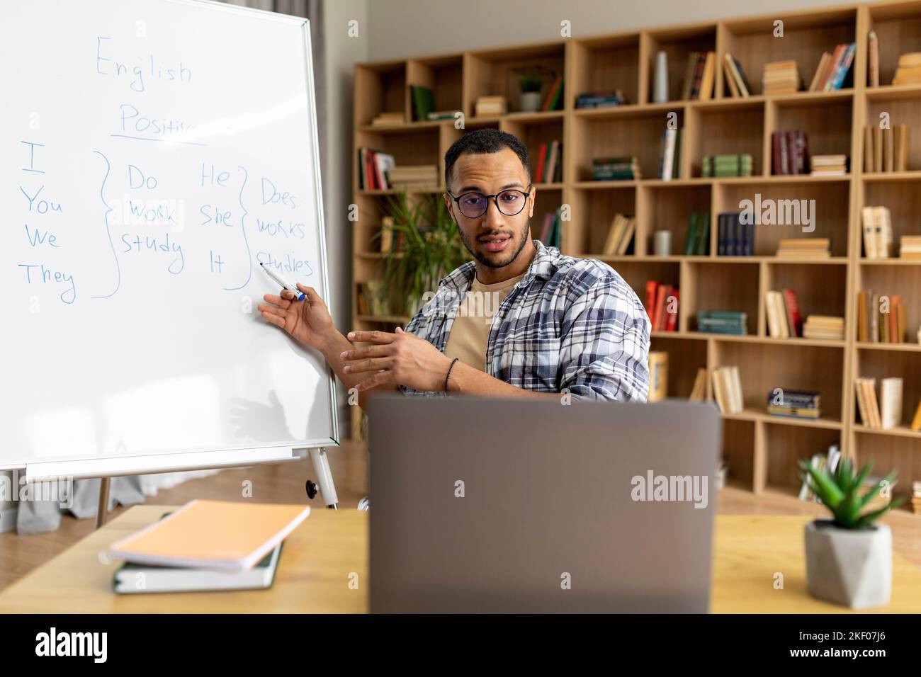 Cyberlearning, remote education concept. Arab male teacher giving online English lesson, using ...