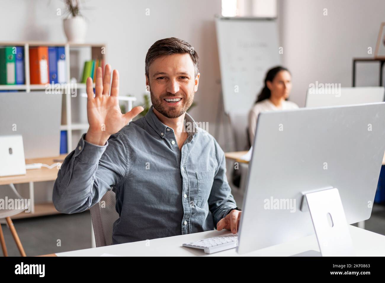 Smiling man waving hand hi-res stock photography and images - Alamy