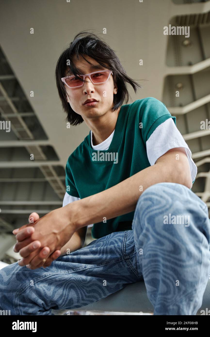 Vertical portrait of street style Asian man looking at camera outdoors ...