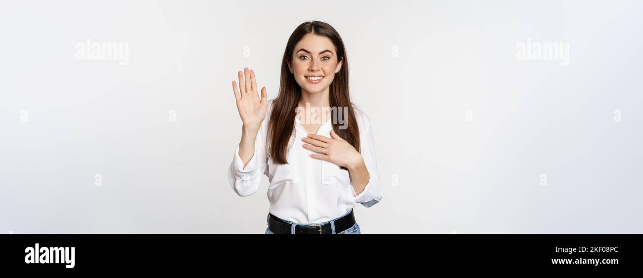 Friendly cute woman raising hand and introduce herself, saying name ...