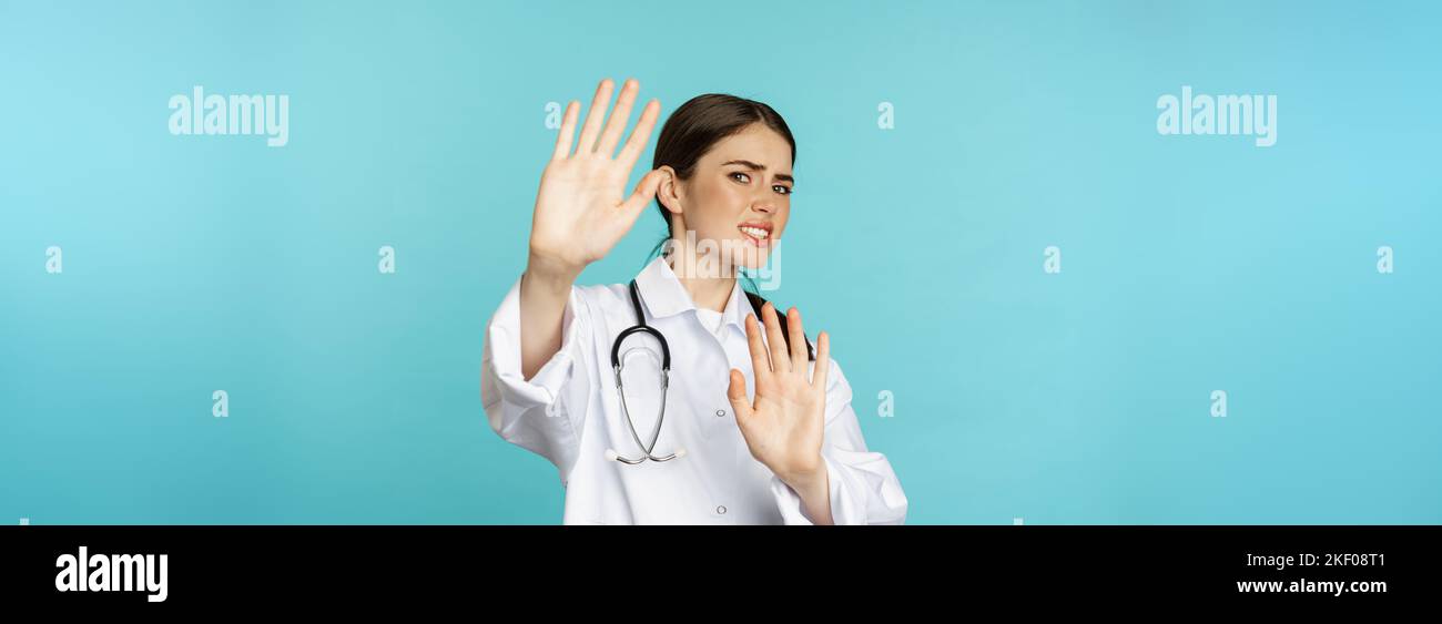 Image of woman doctor cringe, looking with dislike or aversion ...