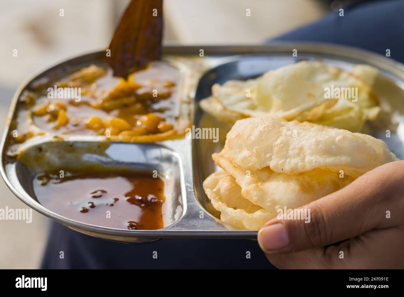 luchi or puri served on a steel plate with potato curry and chutney ...