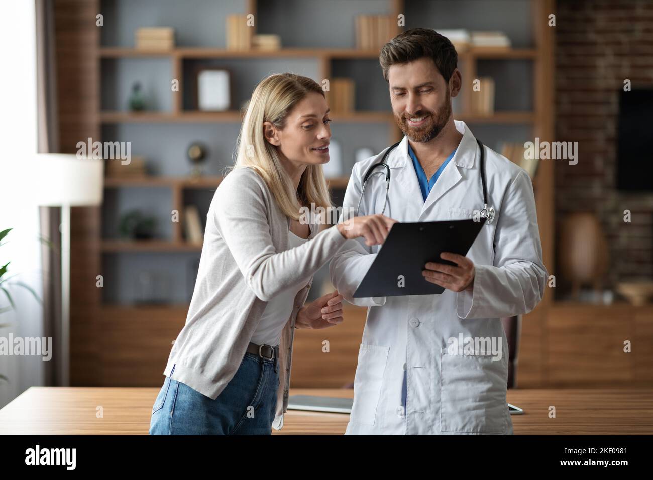 Handsome Male Doctor In Uniform Discussing Treatment With Female ...