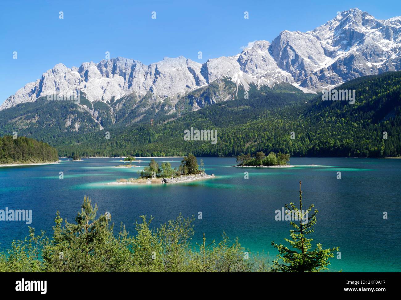 picturesque overgrown islands on turquois alpine lake Eibsee (yew lake ...