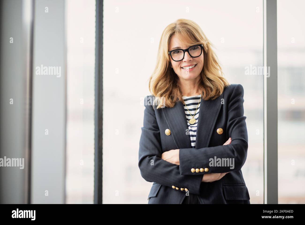Attractive middle aged business woman wearing blazer and smiling while ...