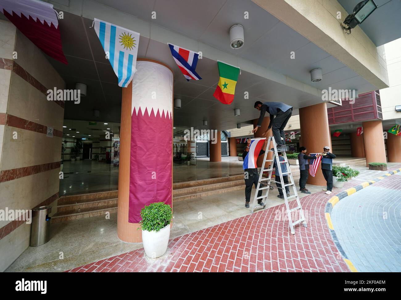 Workers hang flags of competing nations ahead of the FIFA World Cup ...