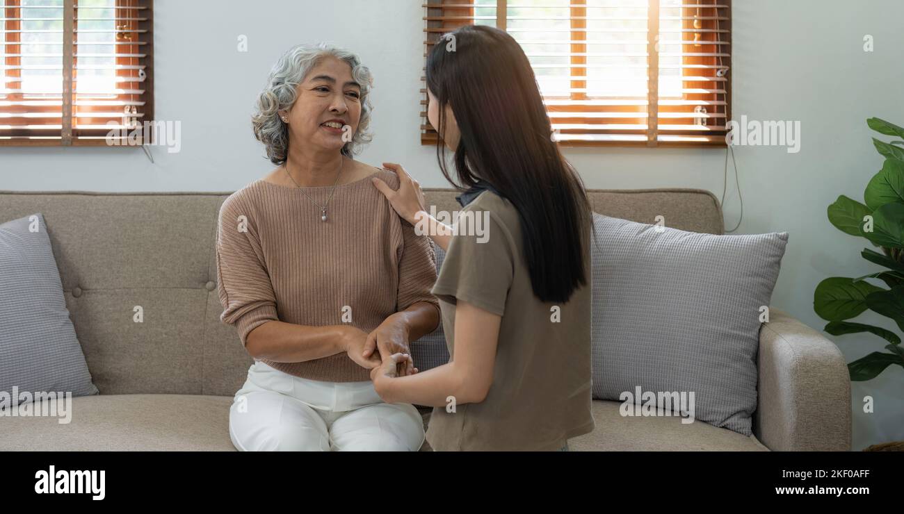 Loving adult daughter hugging older mother on couch at home, family ...