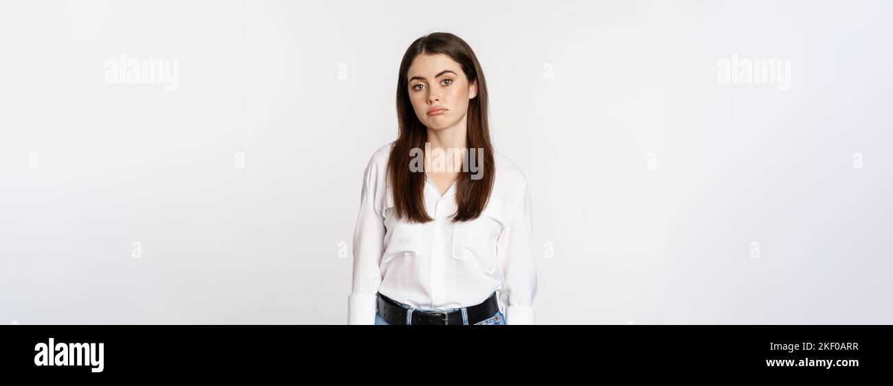 Sad and gloomy woman sulking, looking disappointed and moody, standing ...