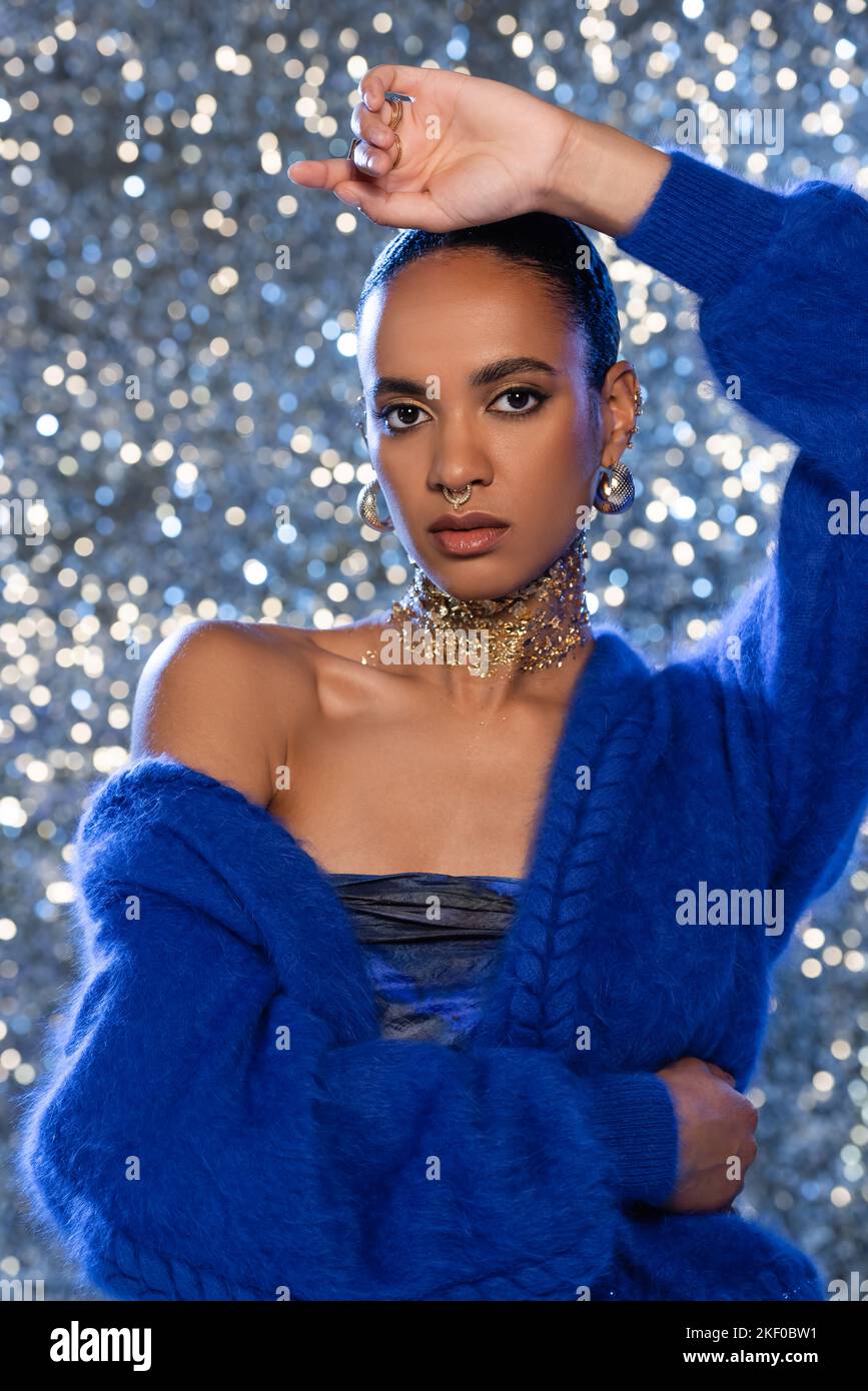 Trendy african american model in jacket and golden accessories on ...