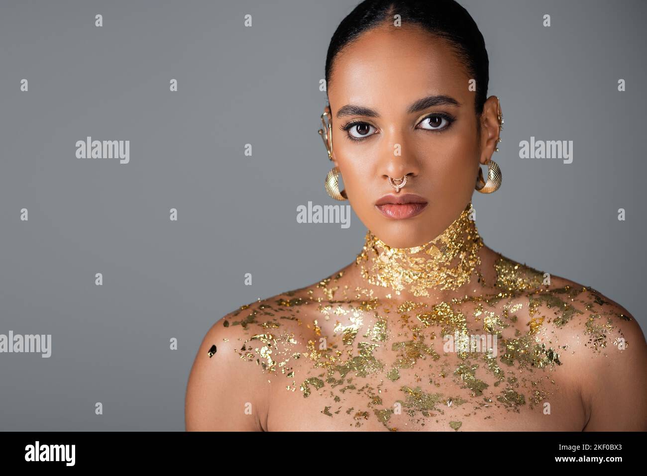 African american model with golden accessories and foil on chest ...