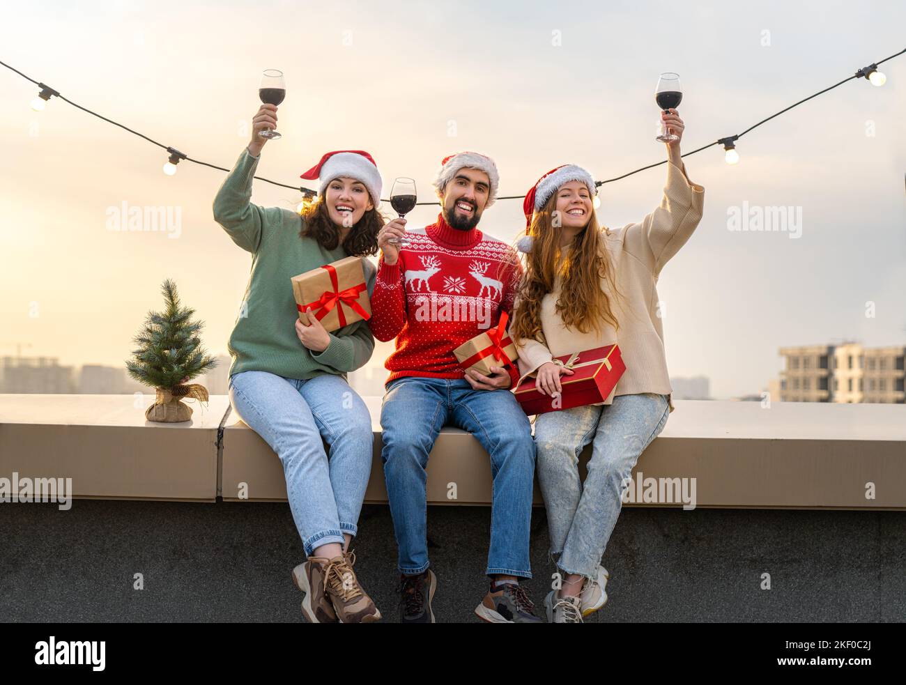 Happy friends are celebrating Christmas outdoors. Adults are having fun ...