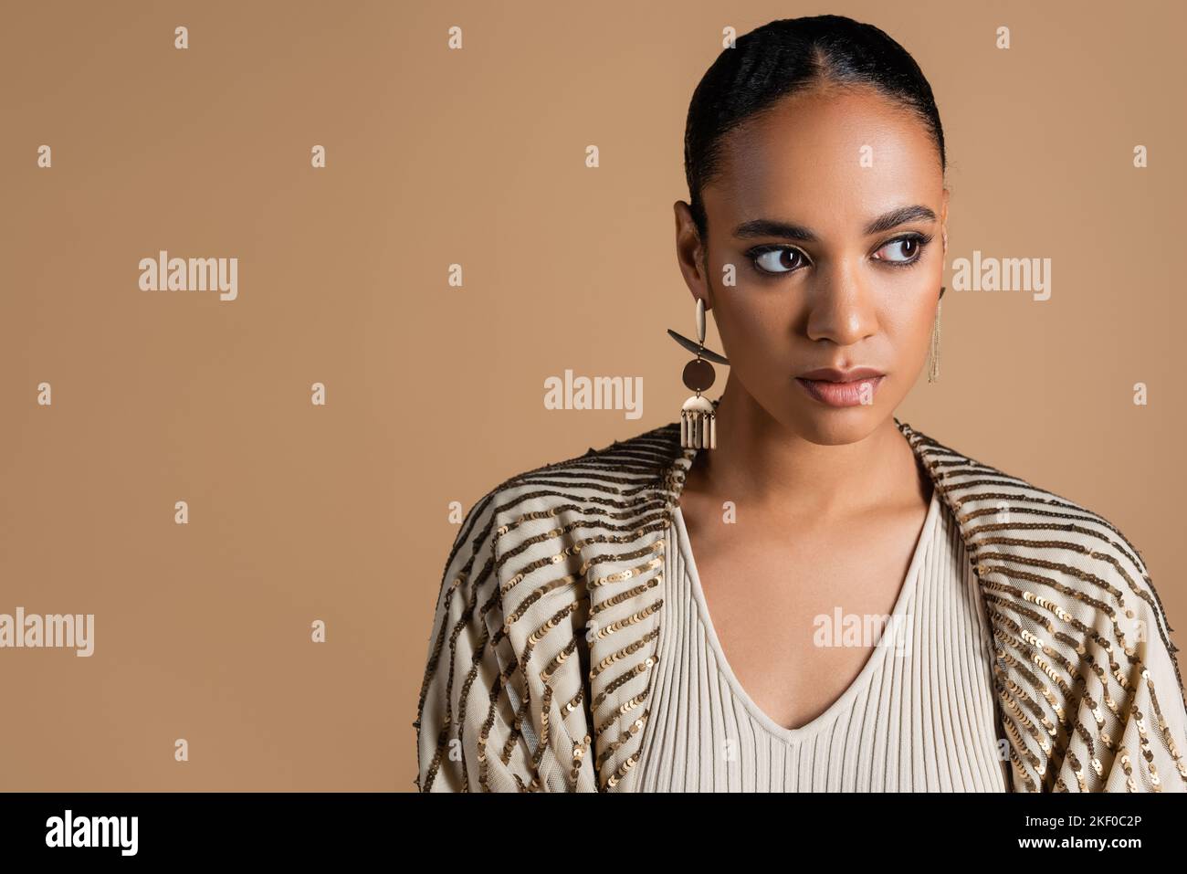 Elegant african american model in shawl looking away isolated on beige ...