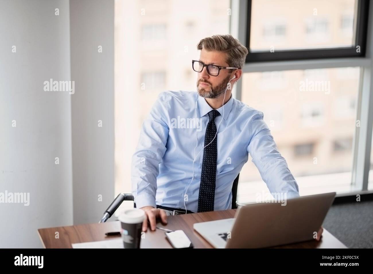 Tired middle aged businessman working at the office and using laptop ...