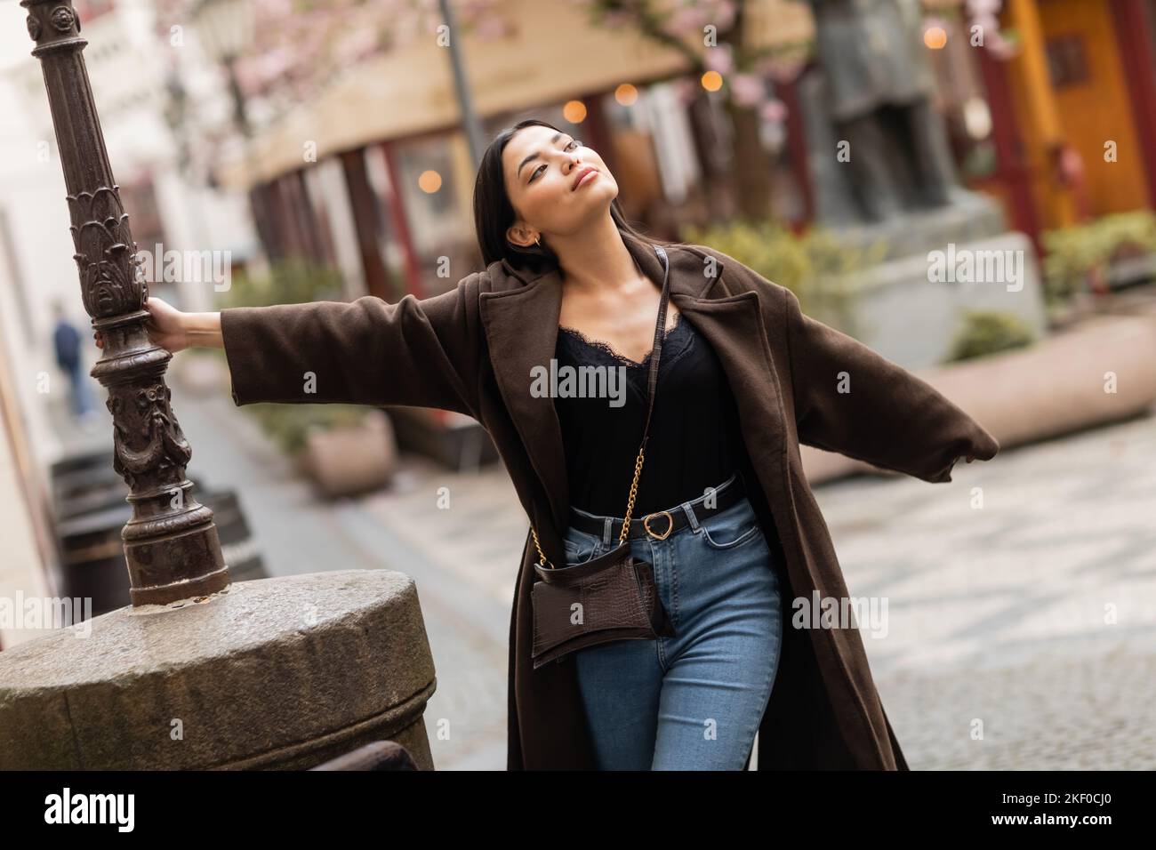 pretty and stylish woman in autumn clothes posing near lamppost in ...