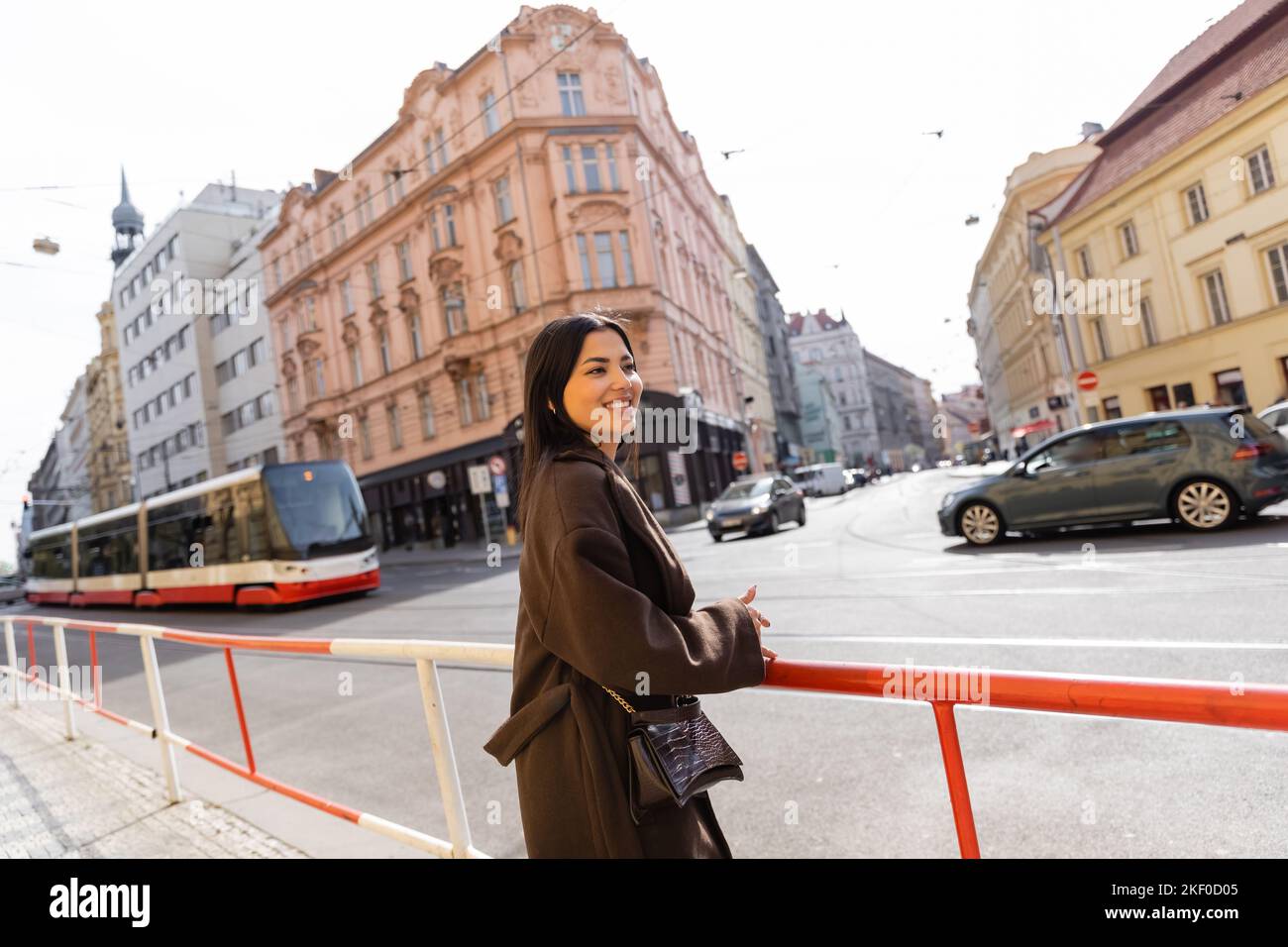 Happy traveler in coat standing near road on street in Prague,stock ...