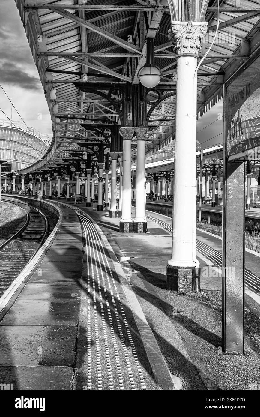 A railway station after a rainfall. Water glistens on the platform and ...