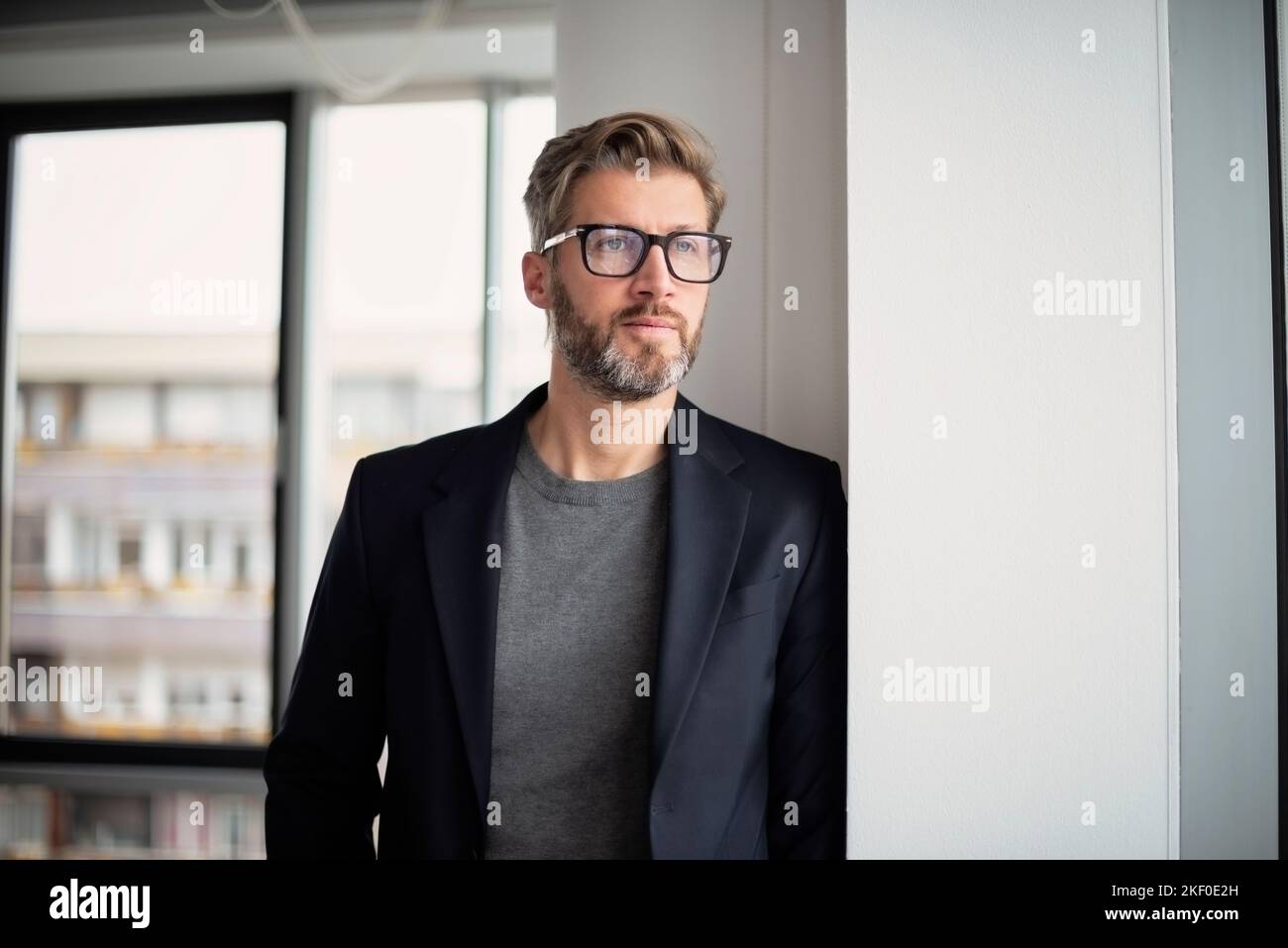 Close-up of thinking businessman wearing a sweater with a suit while ...