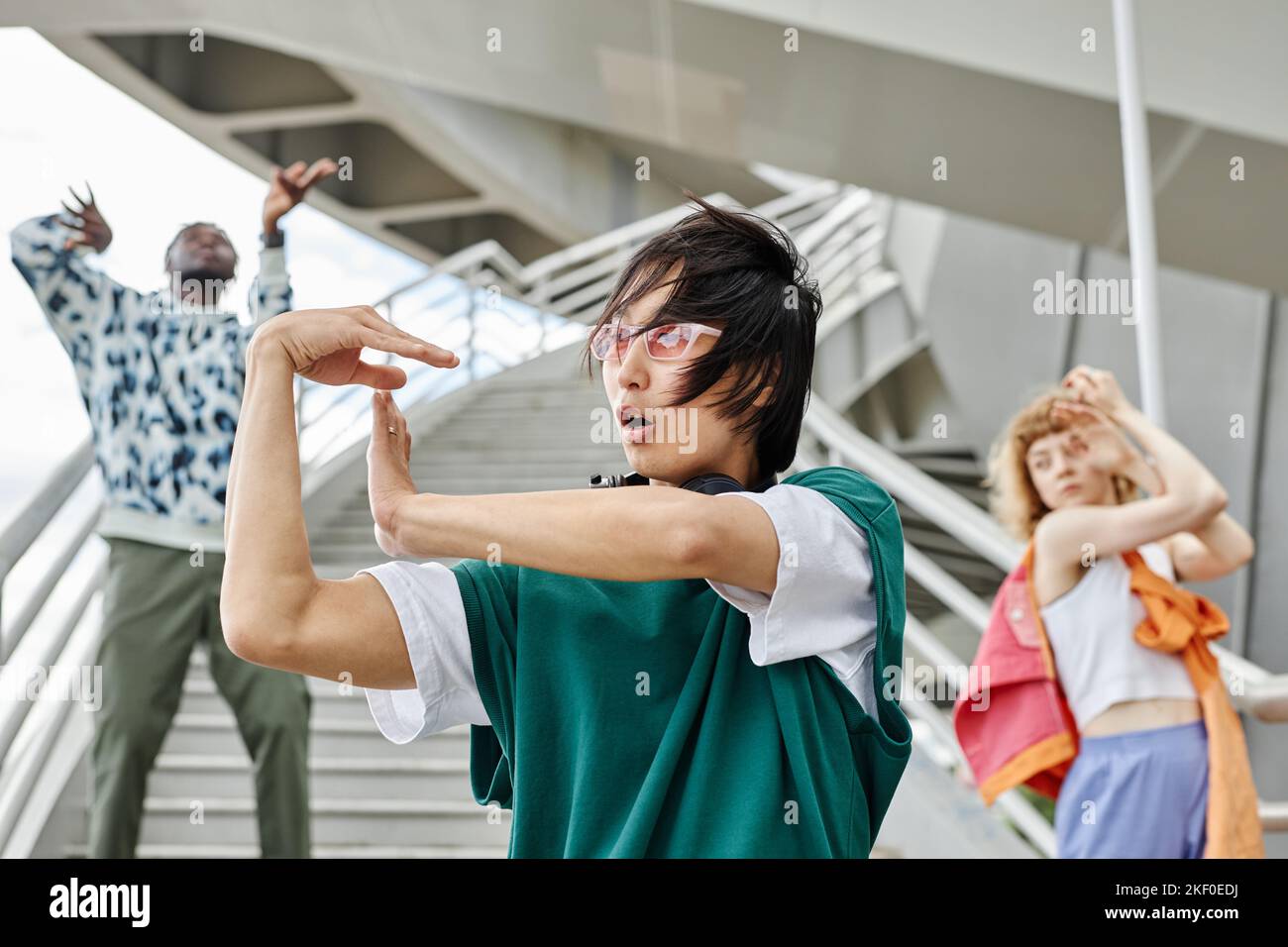 Diverse group of young people dancing outdoors and wearing street style ...