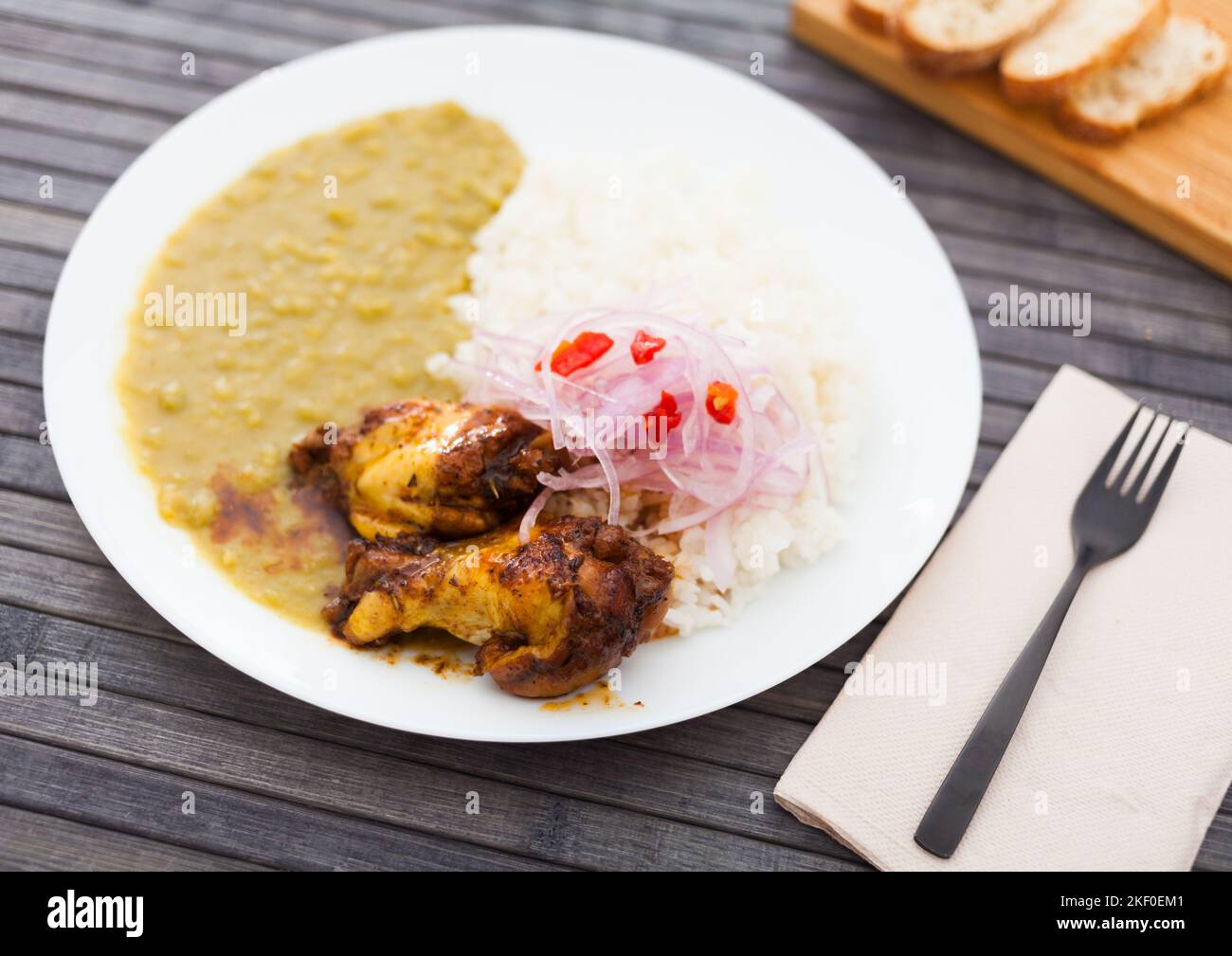 Peruvian dish. chicken wings with pea puree, rice and pickled onions ...