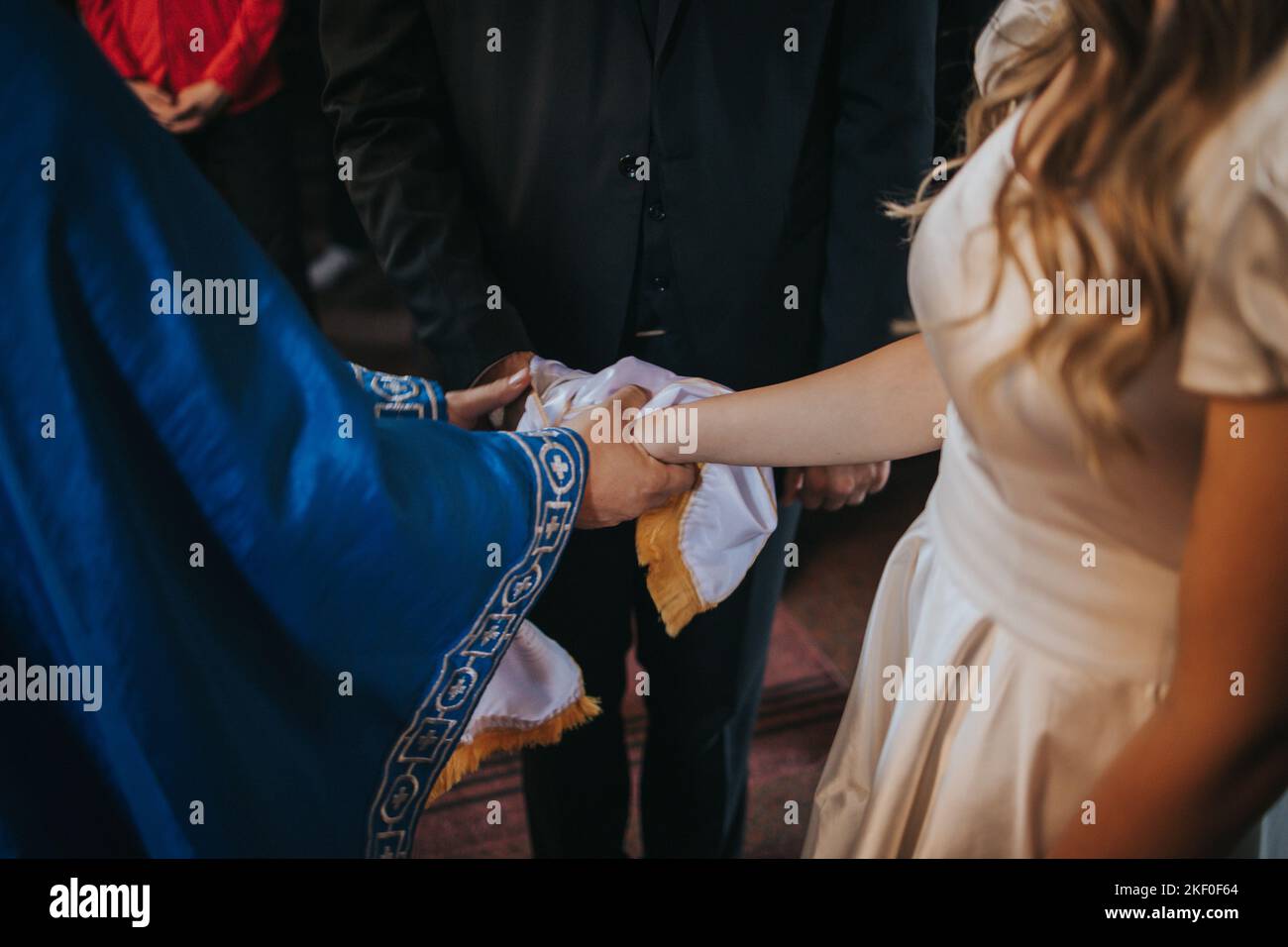 A closeup of groom and bride standing in front of priest Stock Photo ...