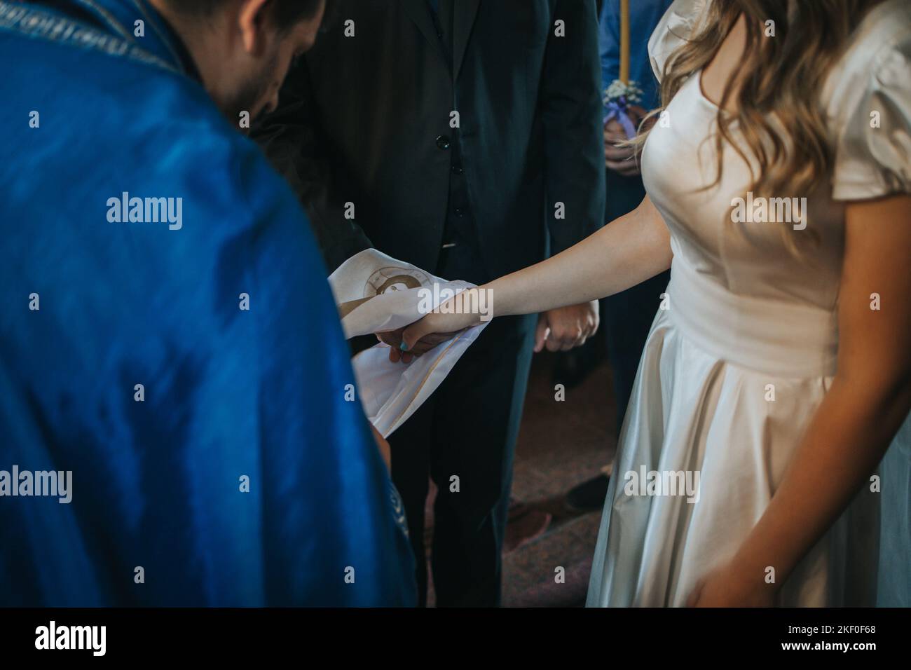 A closeup of groom and bride standing in front of priest Stock Photo ...