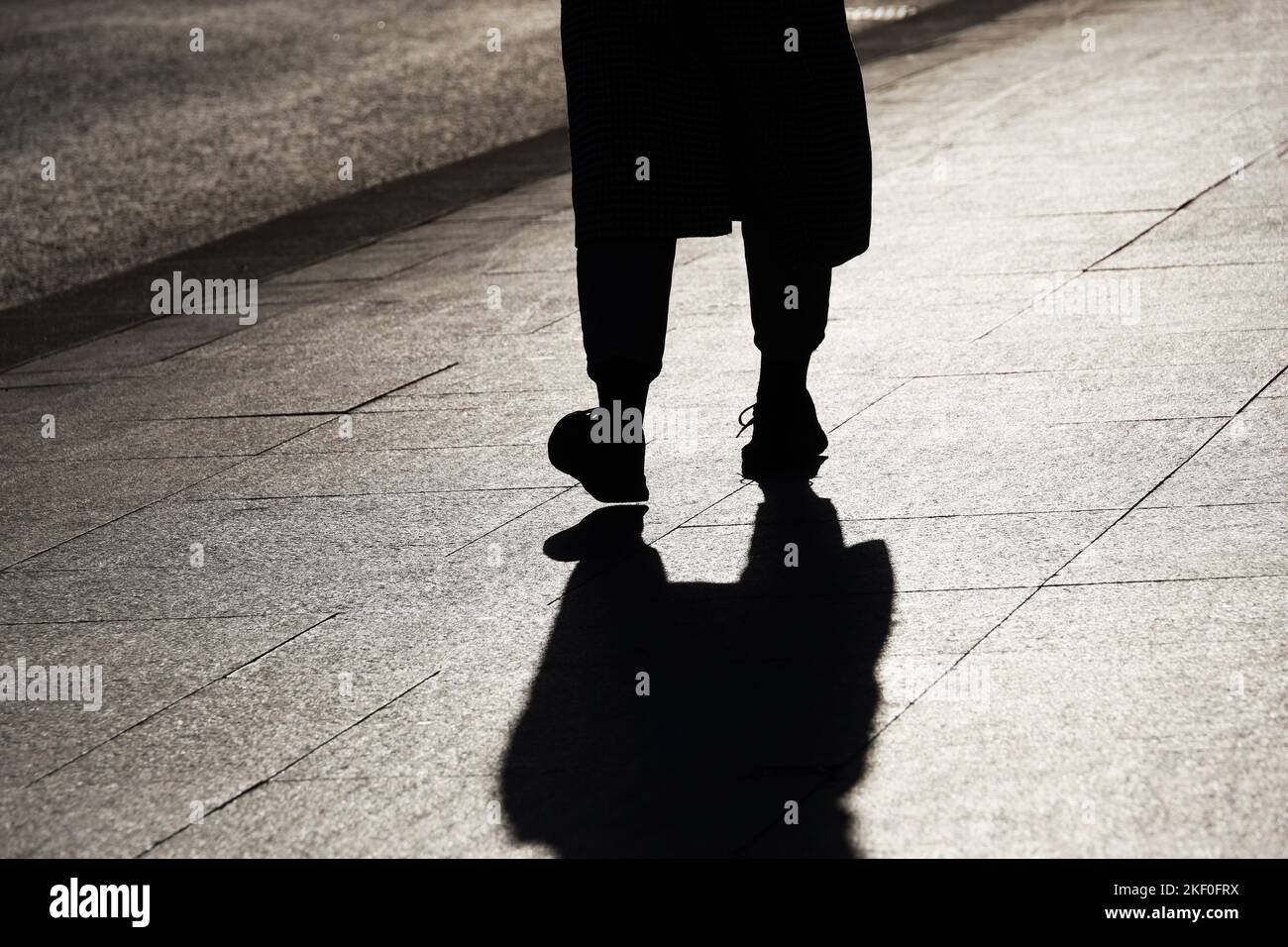 Black silhouette and shadow of lonely woman walking on a street. Female ...
