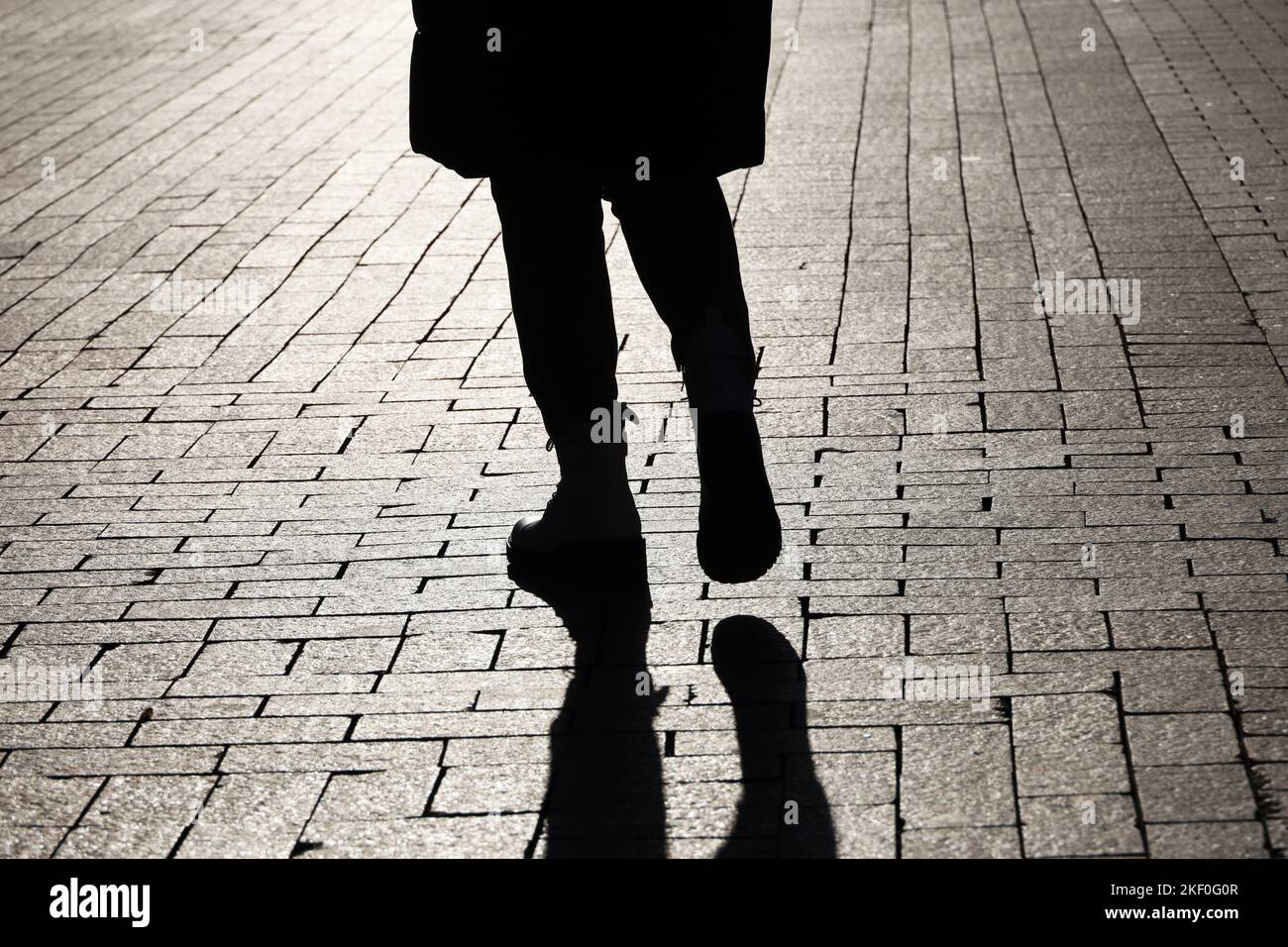 Black silhouette and shadow of lonely woman walking on a street. Female ...