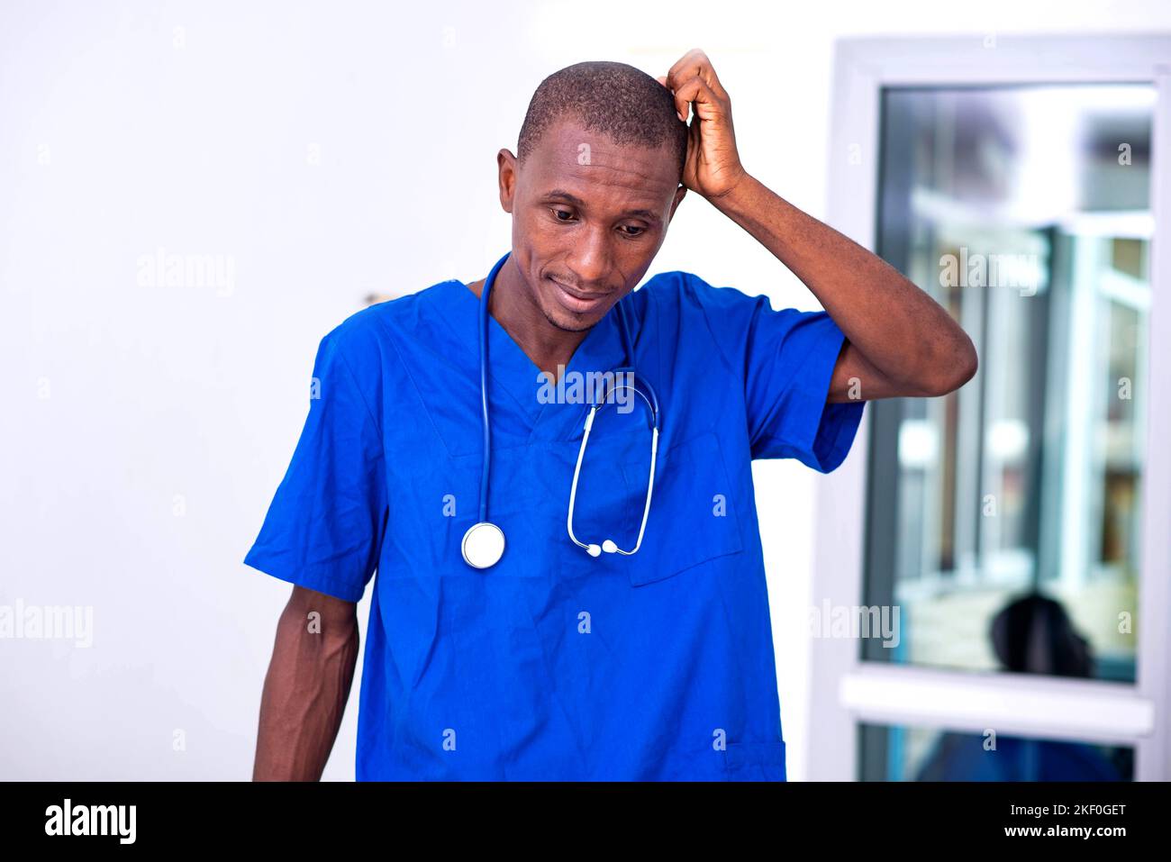 portrait of confused young male doctor, wearing blue uniform at ...