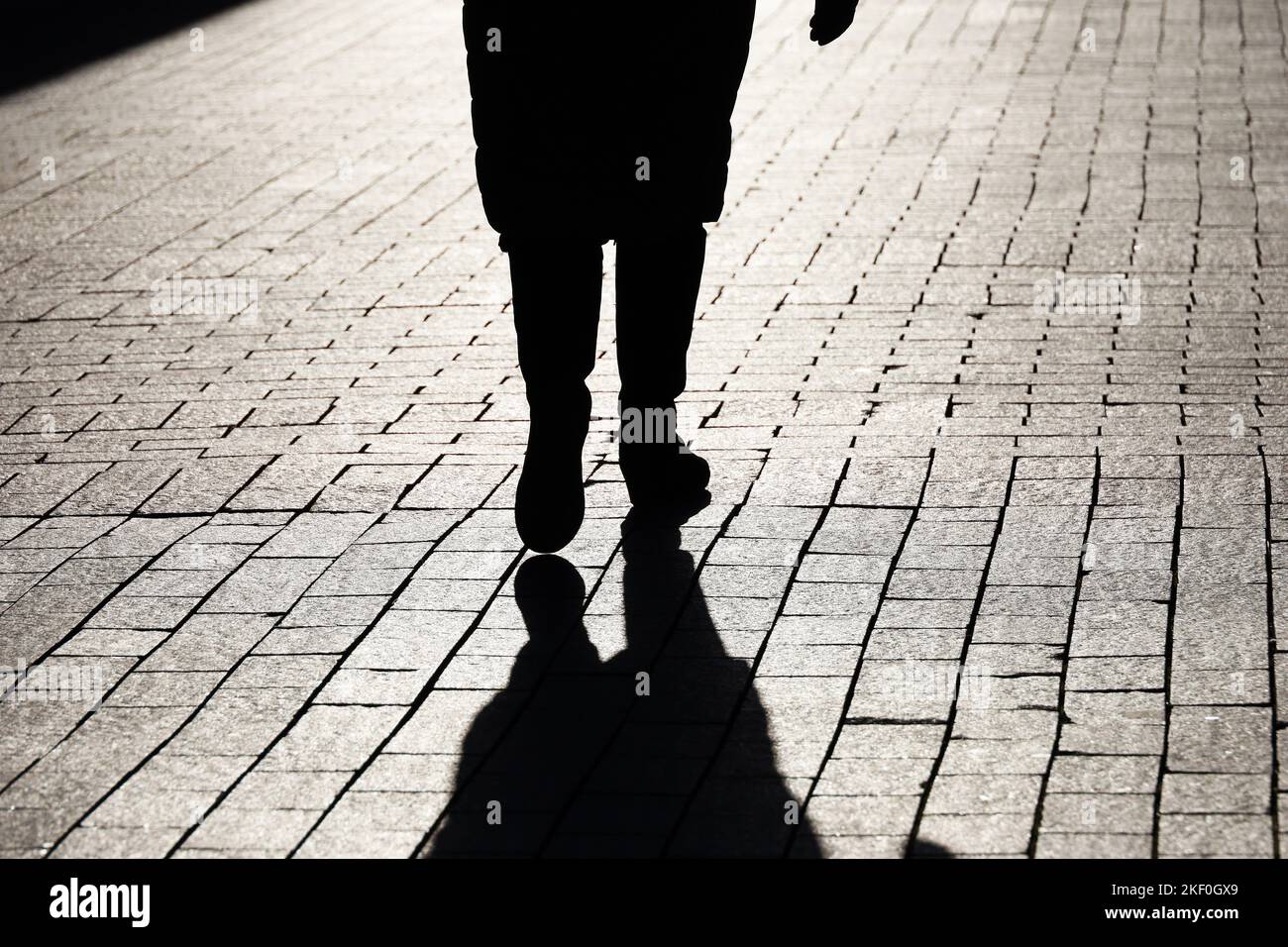 Black silhouette and shadow of lonely woman walking on a street. Female ...