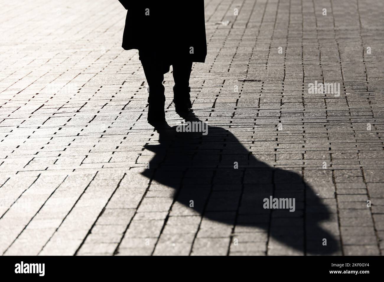 Black silhouette and shadow of lonely woman walking on a street. Female ...