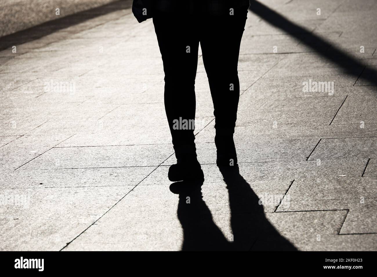 Black silhouette and shadow of overweight woman walking on a street ...