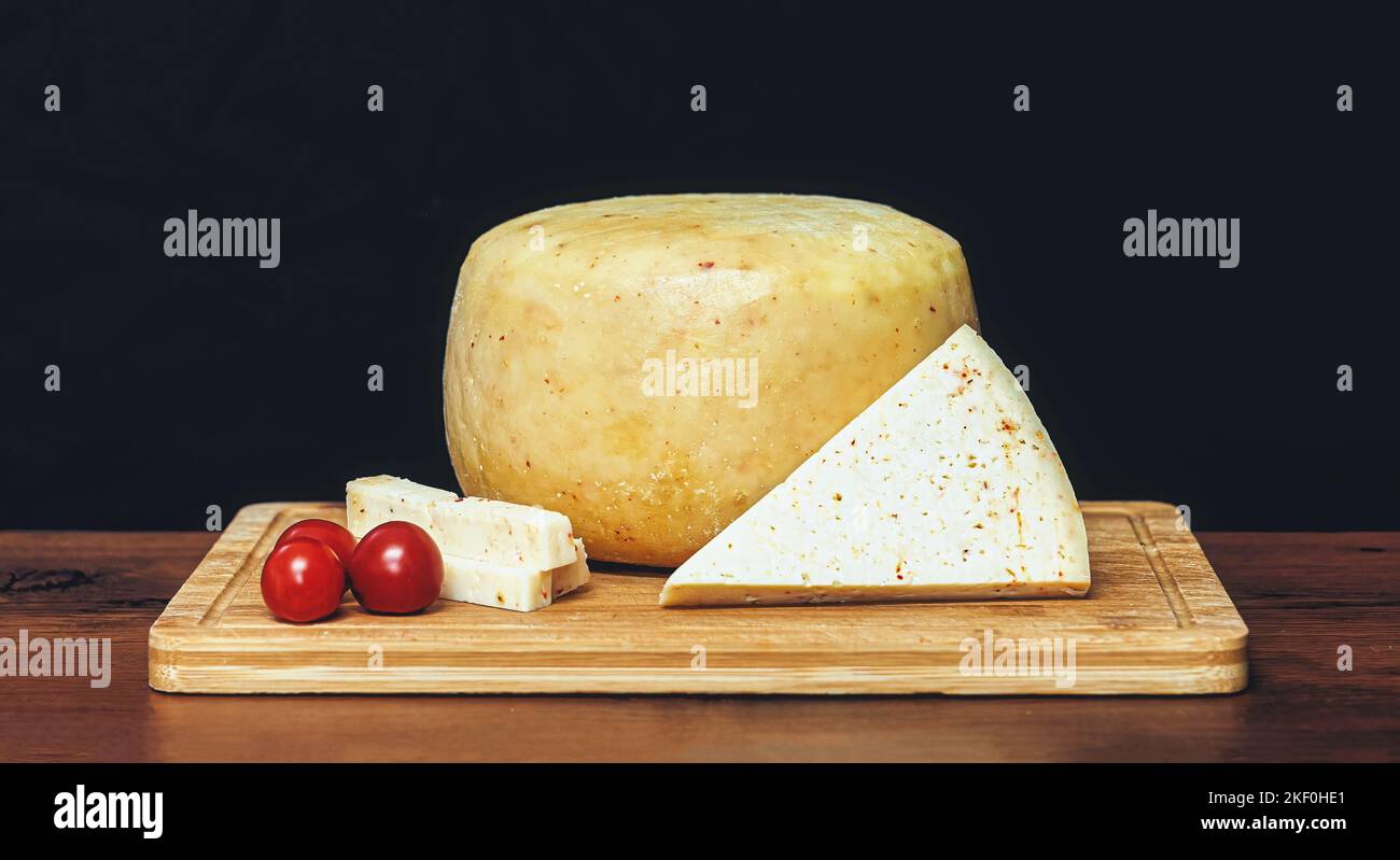 handmade rural cheese on a wooden board with vegetable decoration on ...