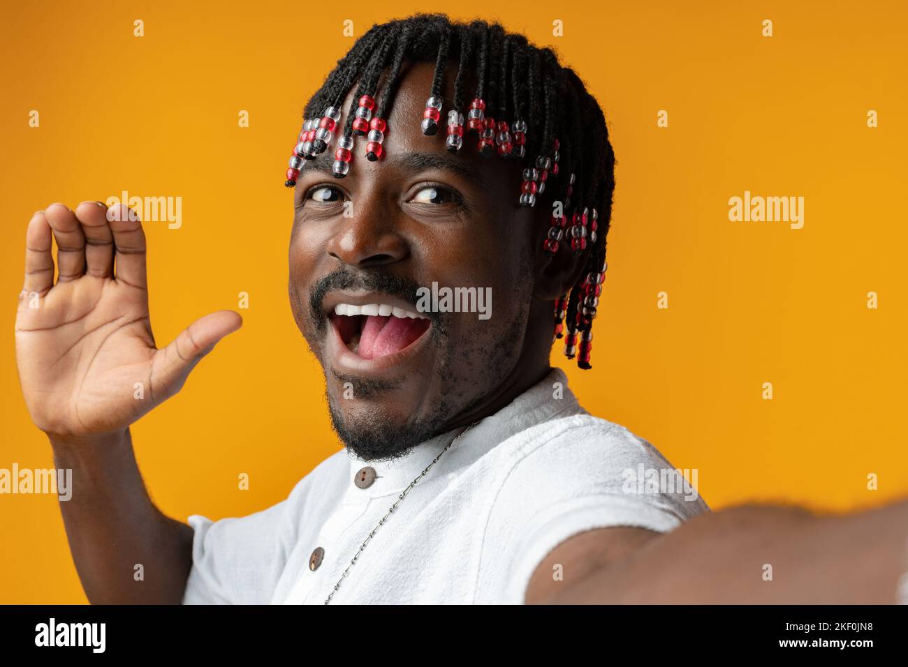 Young african man wearing casual clothes waiving saying hello on yellow ...