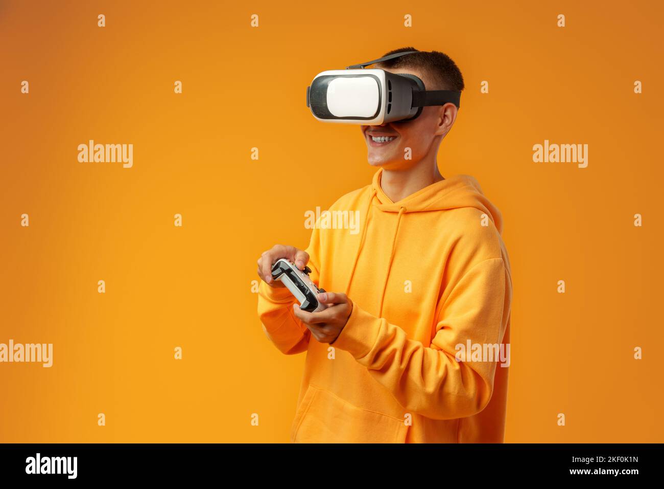 Young man using virtual reality headset against yellow background Stock ...
