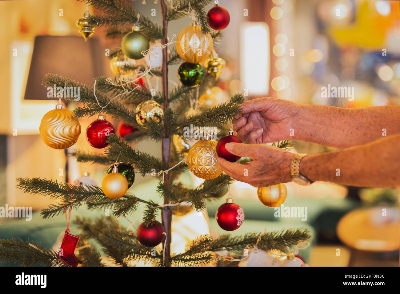 Senior man decorating a Christmas tree at home Stock Photo - Alamy