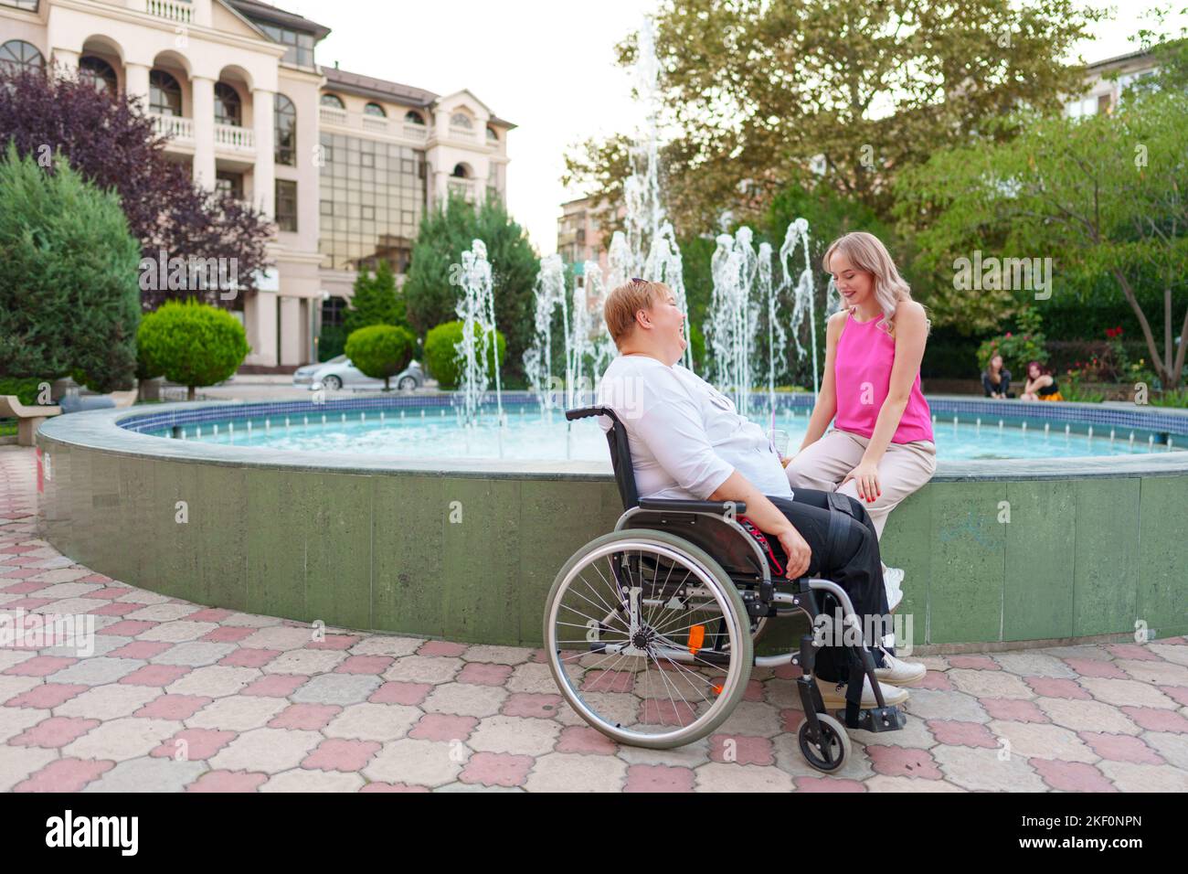 Young daughter taking care of her mother with disability sitting in ...