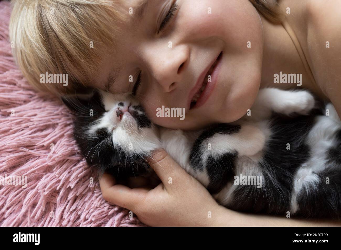 close-up of the face of a preschooler boy lies in an embrace with a ...