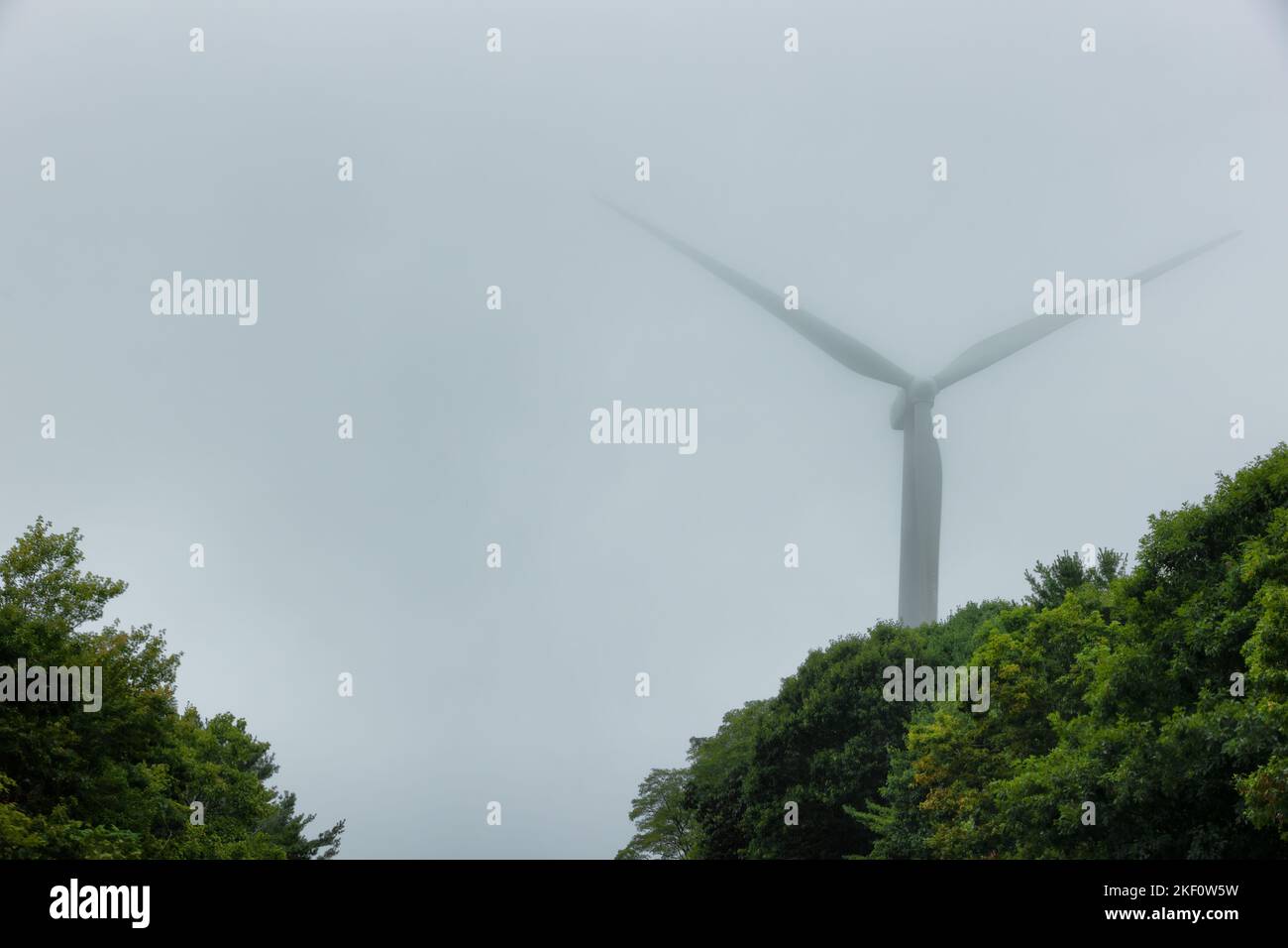 Shot through the windshield of heavy fog nearly obscures the wind mill ...