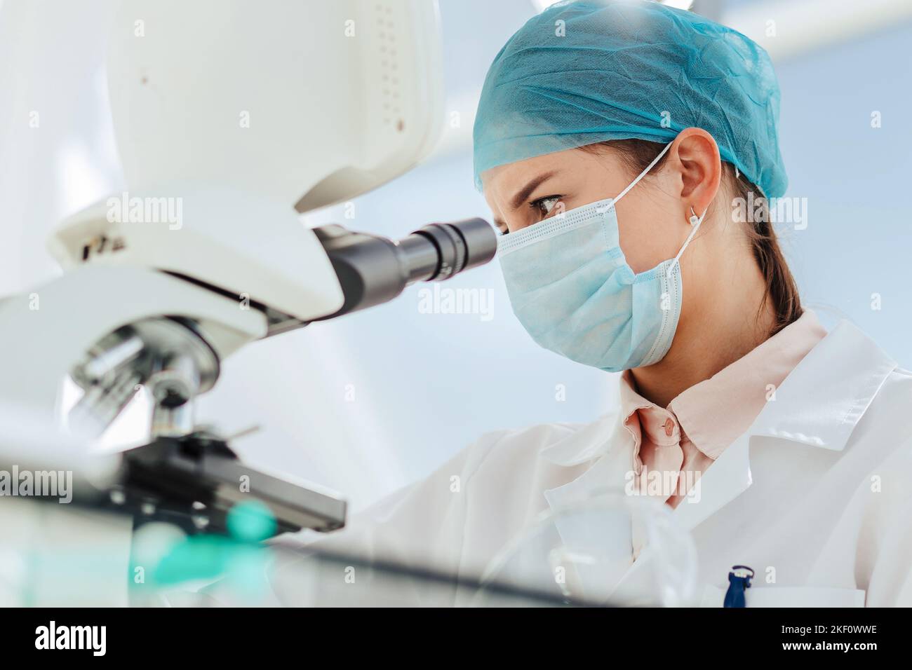 Researcher looking through a microscope hi-res stock photography and ...
