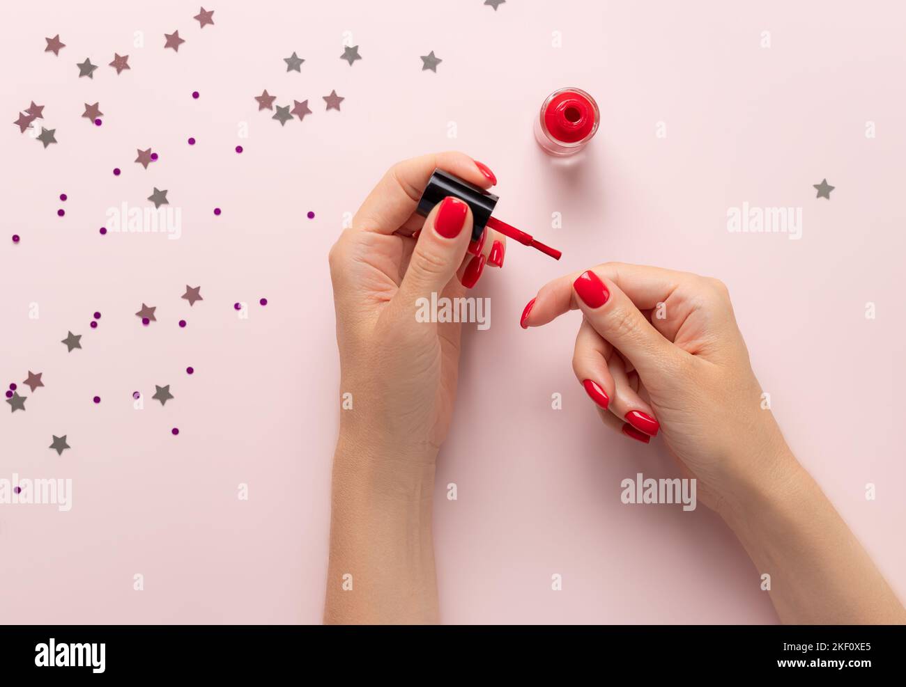 Woman applying red nail polish on her fingers. Manicure process Stock ...