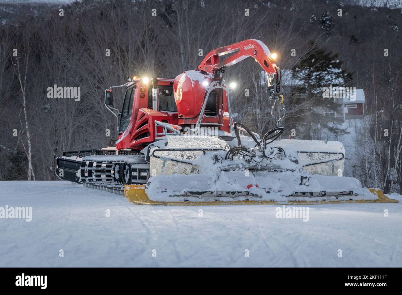 A snowcat with a winch starts its evening grooming on a mountain Stock ...