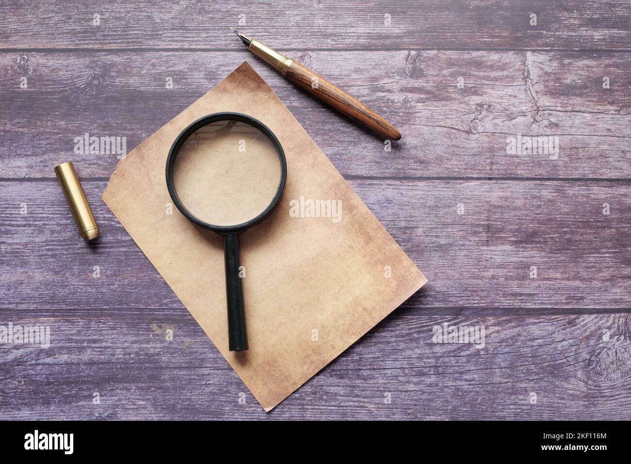 open book and magnifying glass on table Stock Photo - Alamy