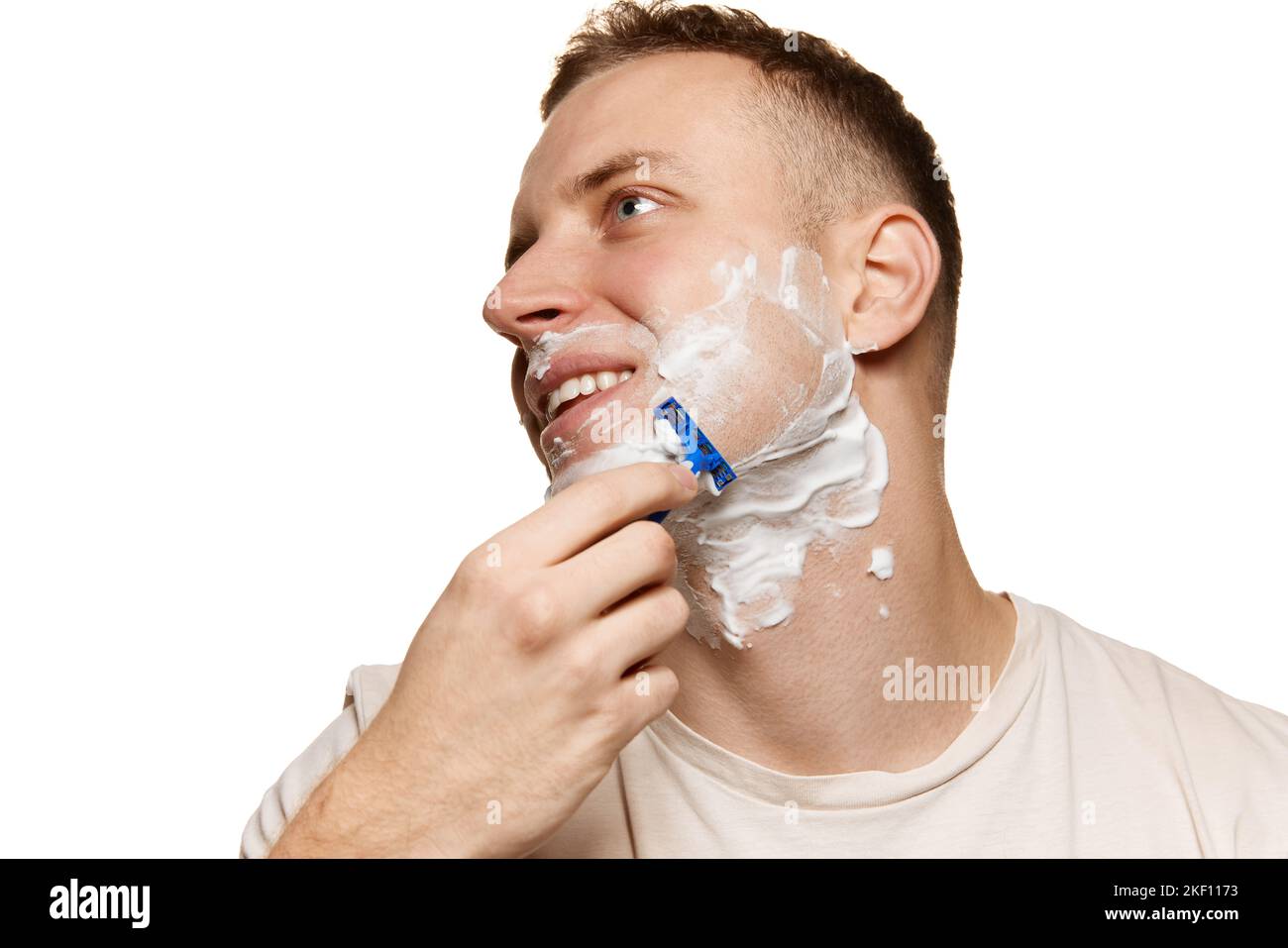 Smooth skin. Man shaving face with cream isolated over white studio ...