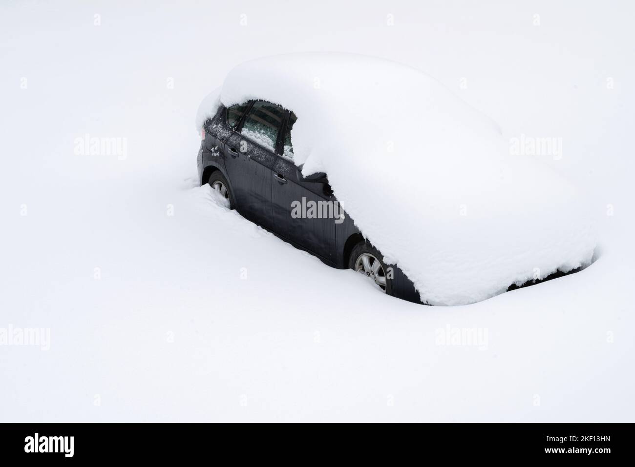 Car covered with thick layer of snow. Automobile after snowstorm parked ...