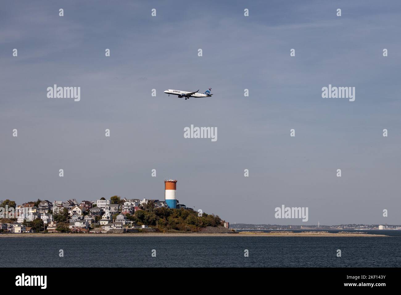 A JetBlue airlines plane flying over a beach before landing in Boston ...