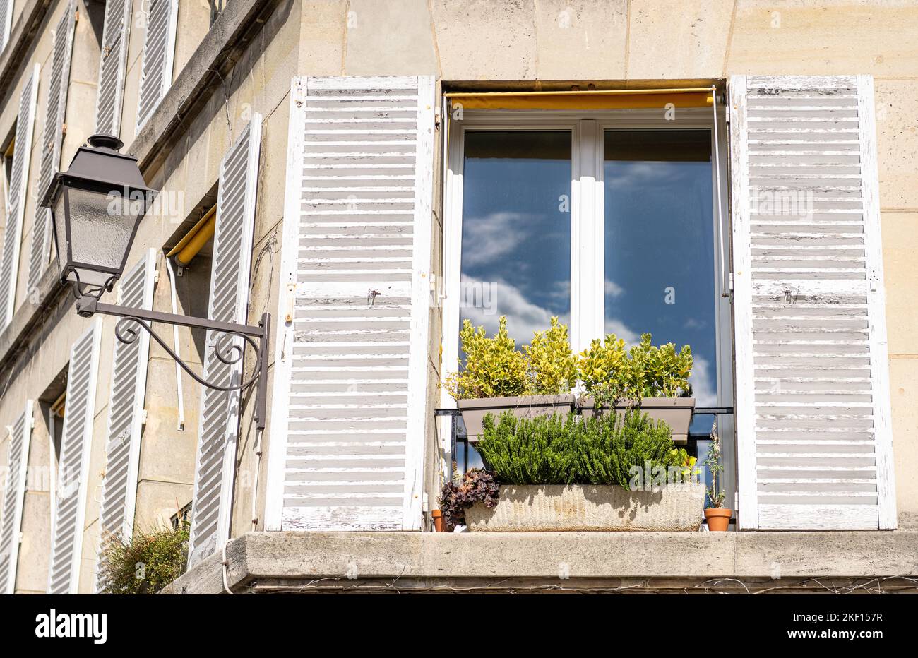 Traditional shuttered window with window box and traditional street ...