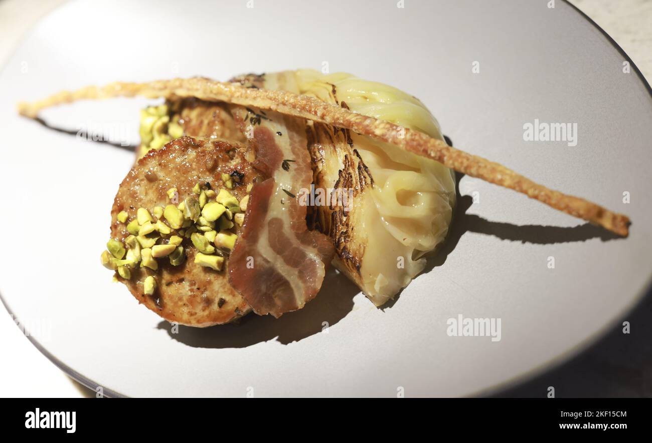 Dishes of Truffled saucisson Lyonnaise, hispi cabbage, pistachios and ...