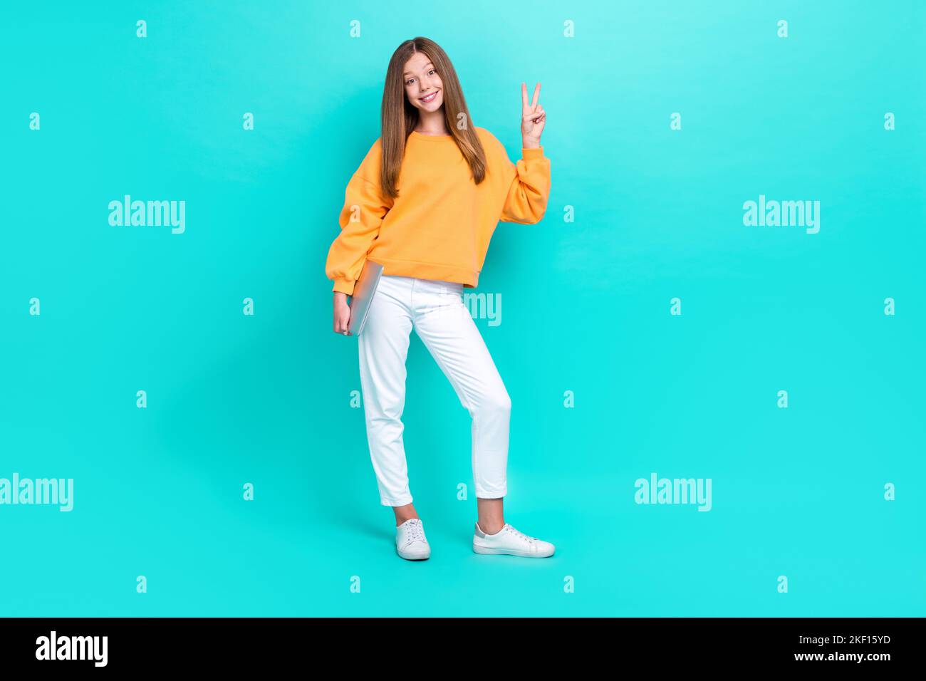 Full length photo of satisfied cute girl showing v-sign hold netbook ...