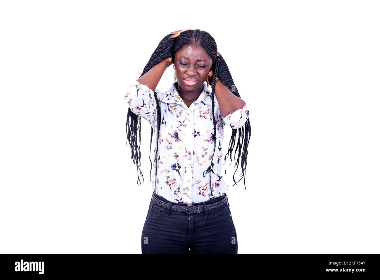 a young woman in a shirt standing on a white background with braids ...