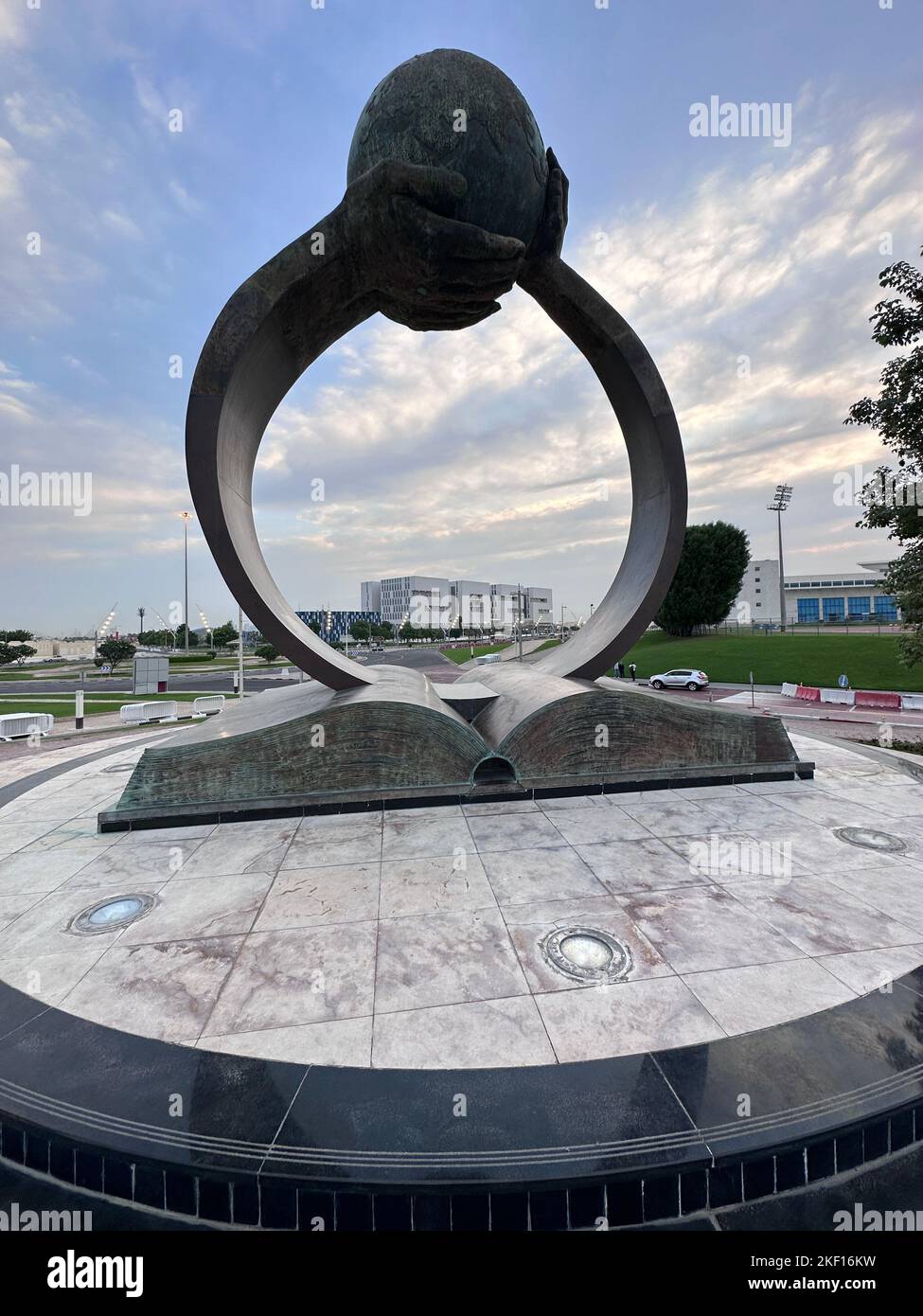Hands rising from a book support the globe in this sculpture at Qatar's ...